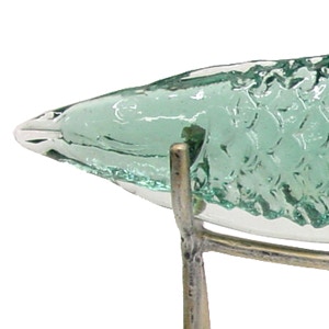 Hand-cast recycled glass fish sits loose on a wrought iron silver ...